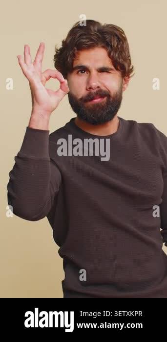 Ok. Joyful happy Lebanese man in long sleeves looking approvingly at ...