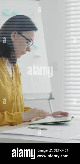 Woman architect or engineer sitting at her office desk, navigating a ...