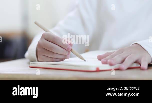 Child hand writing in a notebook with a pencil. Education, learning ...