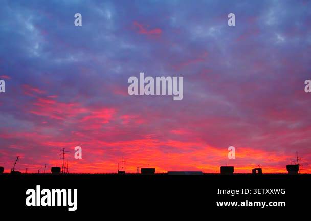 Time lapse. Bright colors fill the sky as day turns to night. The city ...
