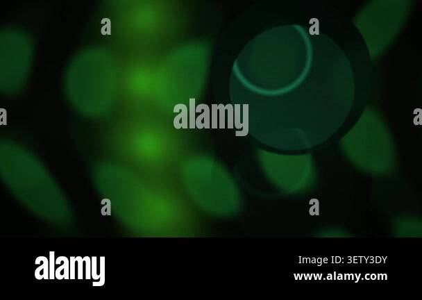 Glowing green orb on dark background with bokeh effect and light ...