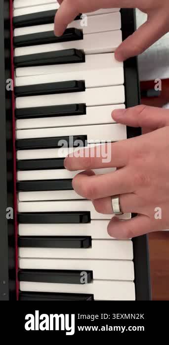 Close-up of hands playing electronic piano keyboard. Fingers on keys ...