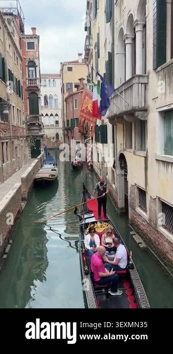 VENICE, ITALY - APRIL 19, 2026: Gondolier steering a traditional wooden ...