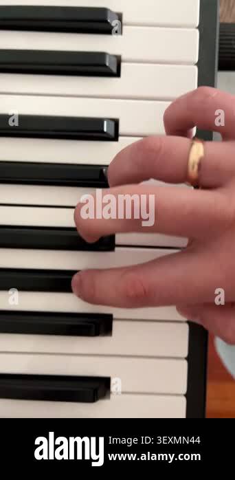 Close-up of hands playing electronic piano keyboard. Fingers on keys ...