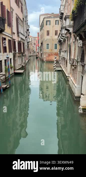 VENICE, ITALY - APRIL 19, 2026: Serene scenery of a narrow water canal ...