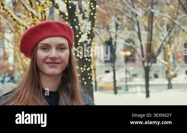 Close-up of a young woman wearing a red hat and red gloves, rushing ...