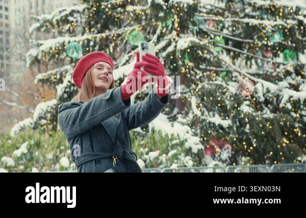 young beautiful woman wearing a gray coat, red beret, and red gloves ...