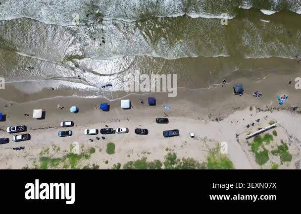 Automobiles park in linear fashion along dunes, offering easy access to ...