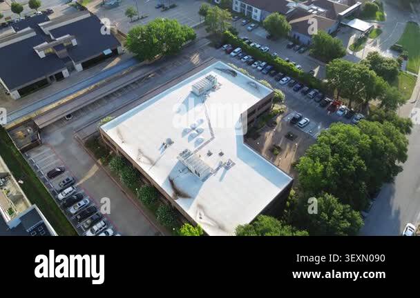 White roofs featuring HVAC units dominate commercial complex surrounded ...