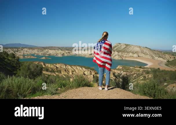 Young woman proudly with American flag enjoy an unforgettable panorama ...