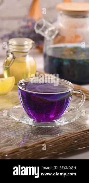 A fresh lemon slice is added to a clear glass cup, reacting with ...