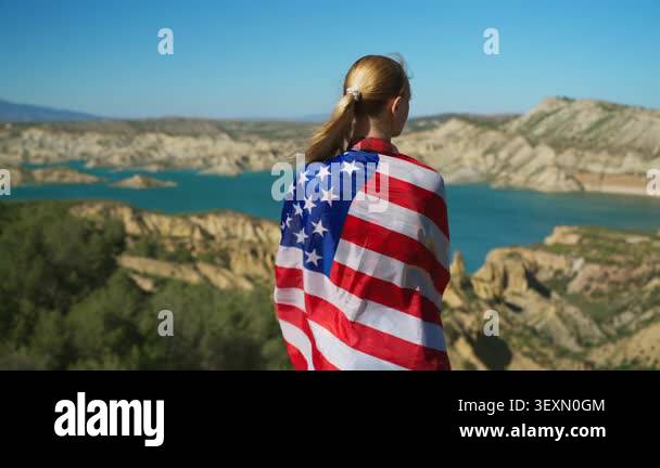 Young woman proudly with American flag enjoy an unforgettable panorama ...