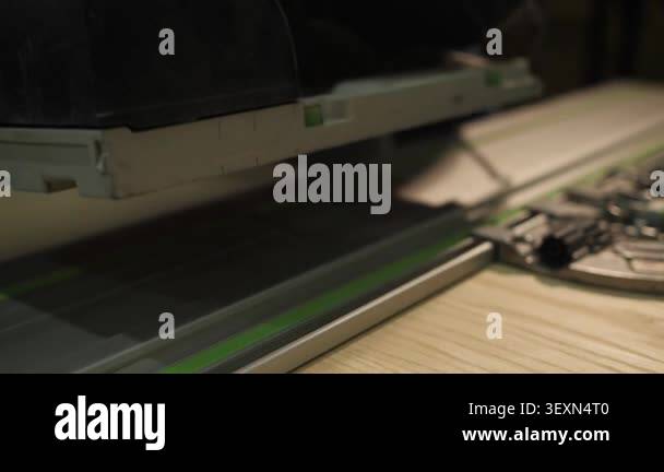 The carpenters hands, pressing a wooden rail against the saw on the ...