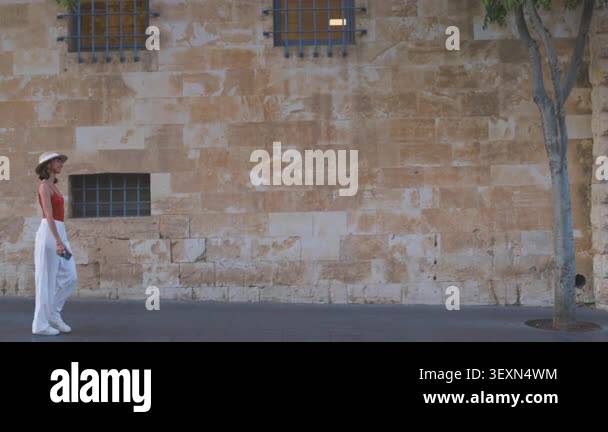 A woman is strolling through Jerusalem. She is smiling and looks happy ...