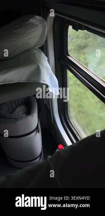 A view from inside a train carriage looking at stacked sleeping bunks ...