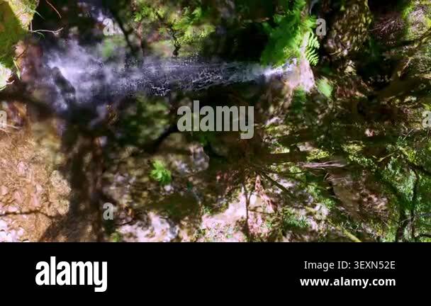 A high angle view captures the Gresso waterfall flowing over textured ...