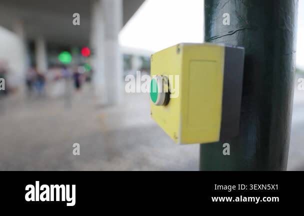 Close up of a pedestrian push button with blurred people and traffic ...