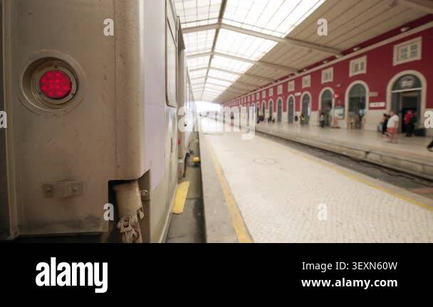 Passengers waiting on the platform as a train arrives and stops at a ...
