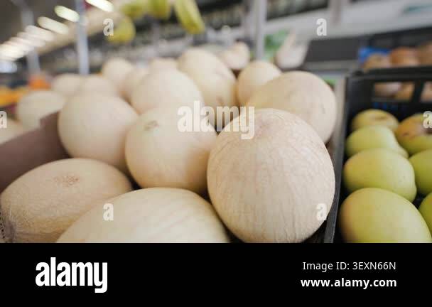 Closeup of fresh ripe melons in a box at a supermarket produce section ...