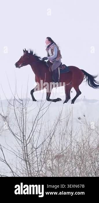 Young woman galloping on snowly outdoor on red horse - slow-motion shot ...