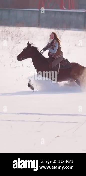 Equestrian sport - rider woman on horse galloping in snowy field ...