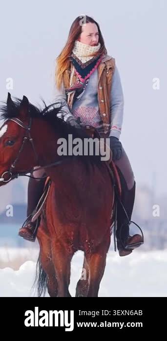 Beautiful longhaired woman riding a brown horse through the deep ...
