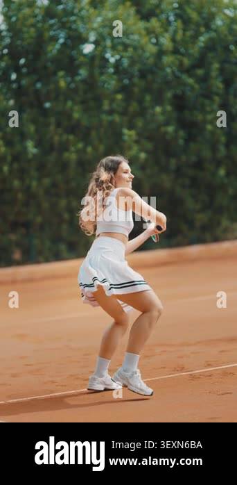 Young woman tennis player in white outfit readies for a powerful shot ...