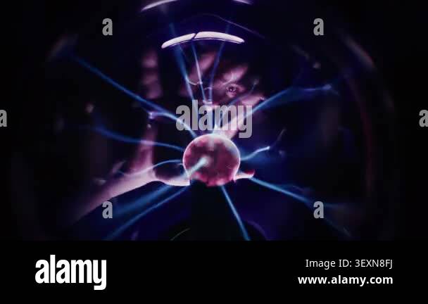 Close up of a scientist in a white coat observing intense high voltage ...