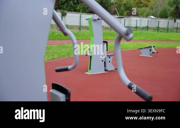 Outdoor gym equipment installed on red rubberized sports surface ...