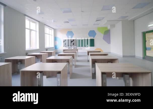 Classroom featuring neat rows of light wood desks and clean floor ...