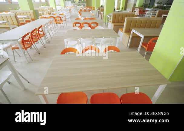 Large spacious school cafeteria features bright columns and rows of ...