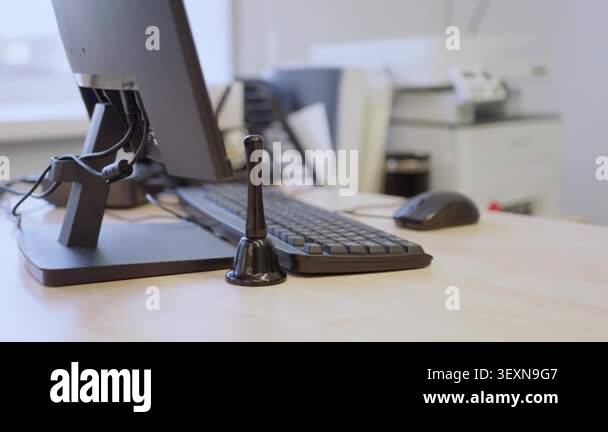 Microphone standing near computer monitor and keyboard. Blurry office ...