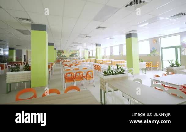 Large school cafeteria features bright columns and rows of neat chairs ...