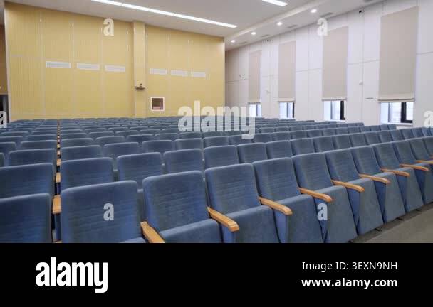 Auditorium stands empty with multiple lines of soft conference seats ...
