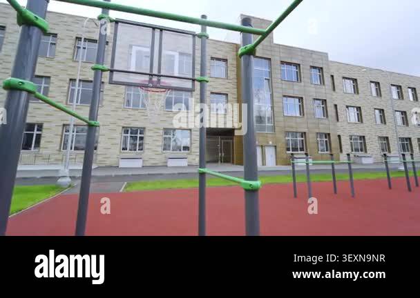 Basketball hoop with transparent backboard stands next to green workout ...
