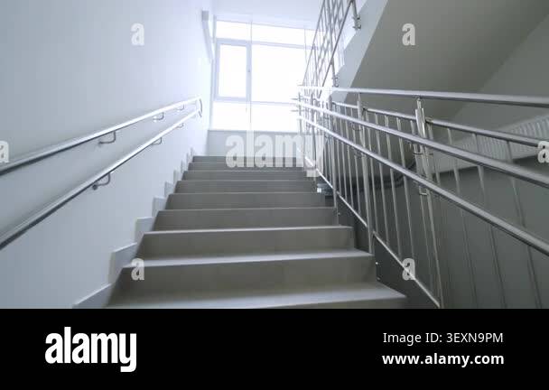 Wide staircase leads toward bright window in modern building. High ...