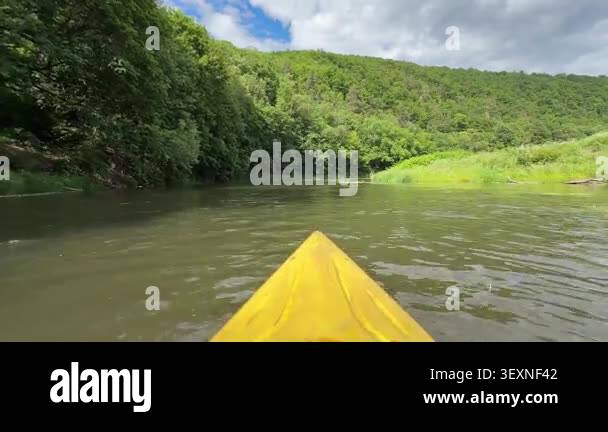 Kayak gliding along a scenic river surrounded by lush greenery Stock ...