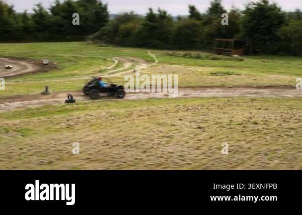 Small off road vehicle driving fast on a muddy circuit during an ...