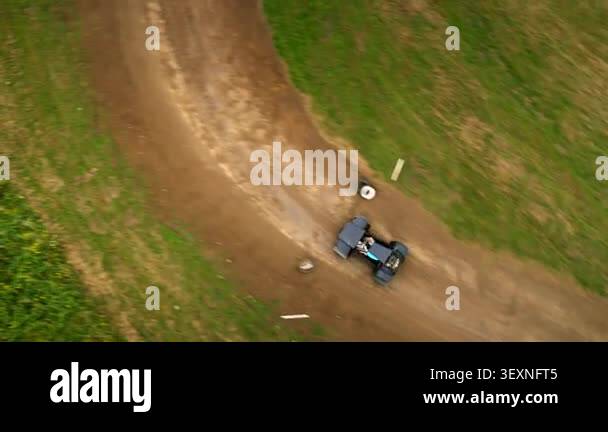 Driver maneuvering an off road buggy at high speed on a dirt race track ...