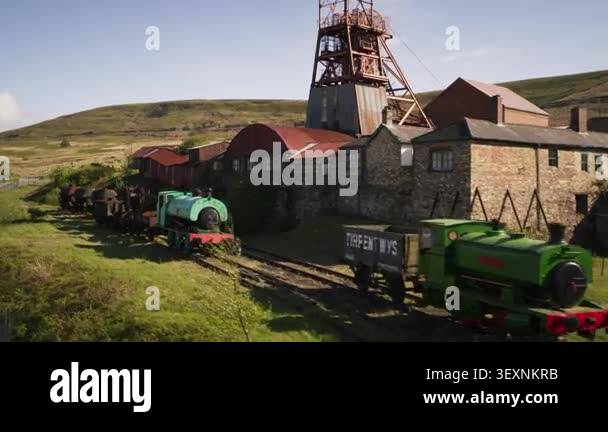 Old steam train with wagons traveling on railway tracks next to a ...