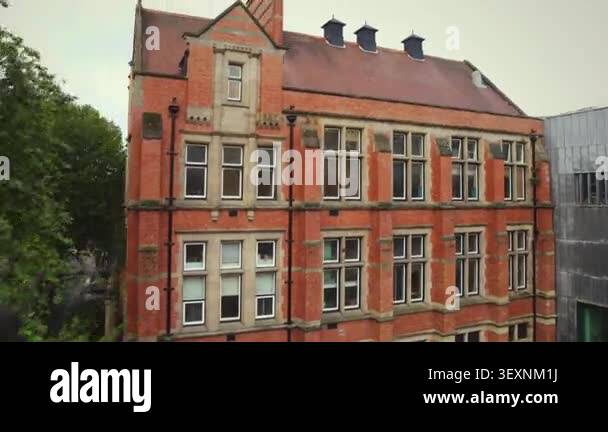 Ascending aerial shot revealing a historic red brick building ...