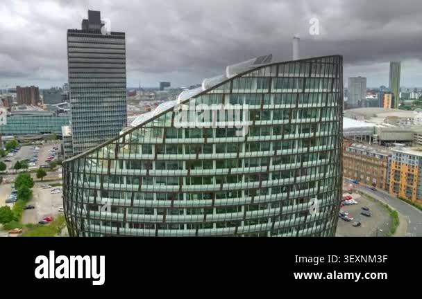 Aerial orbit shot of a modern curved glass office building in the ...