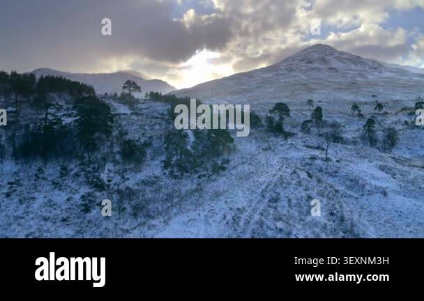 Stunning aerial view flying over a vast, snow covered mountain ...