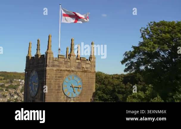 Drone ascending from a church clock tower with the flag of St. George ...