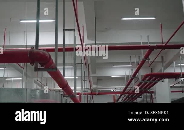 Red fire sprinkler pipes on ceiling of industrial building Stock Video ...