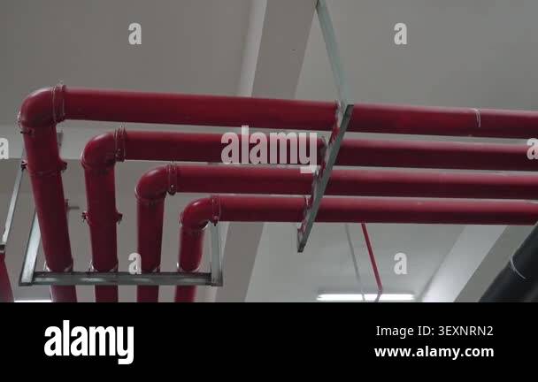 Red fire sprinkler pipes on ceiling of industrial building Stock Video ...