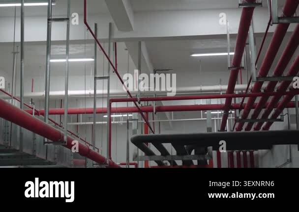 Red fire sprinkler pipes on ceiling of industrial building Stock Video ...