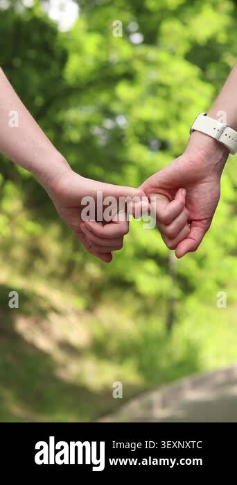 Two girls holding hands. Close-up of two female hands, on a blurred ...