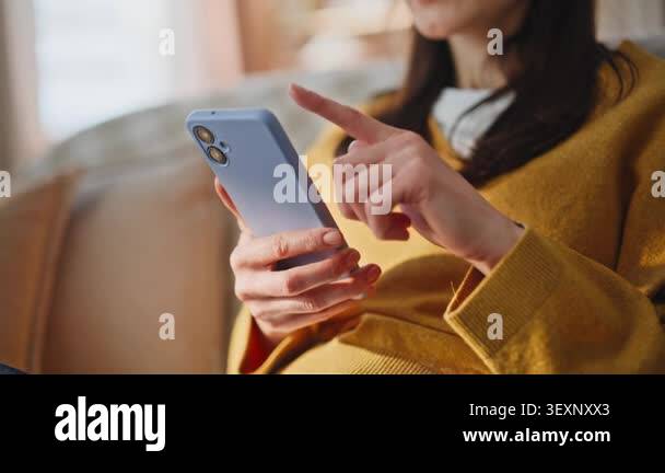 Lady scrolling news feed at cellphone sitting comfortable living room ...