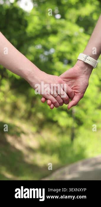 Two girls holding hands. Close-up of two female hands, on a blurred ...
